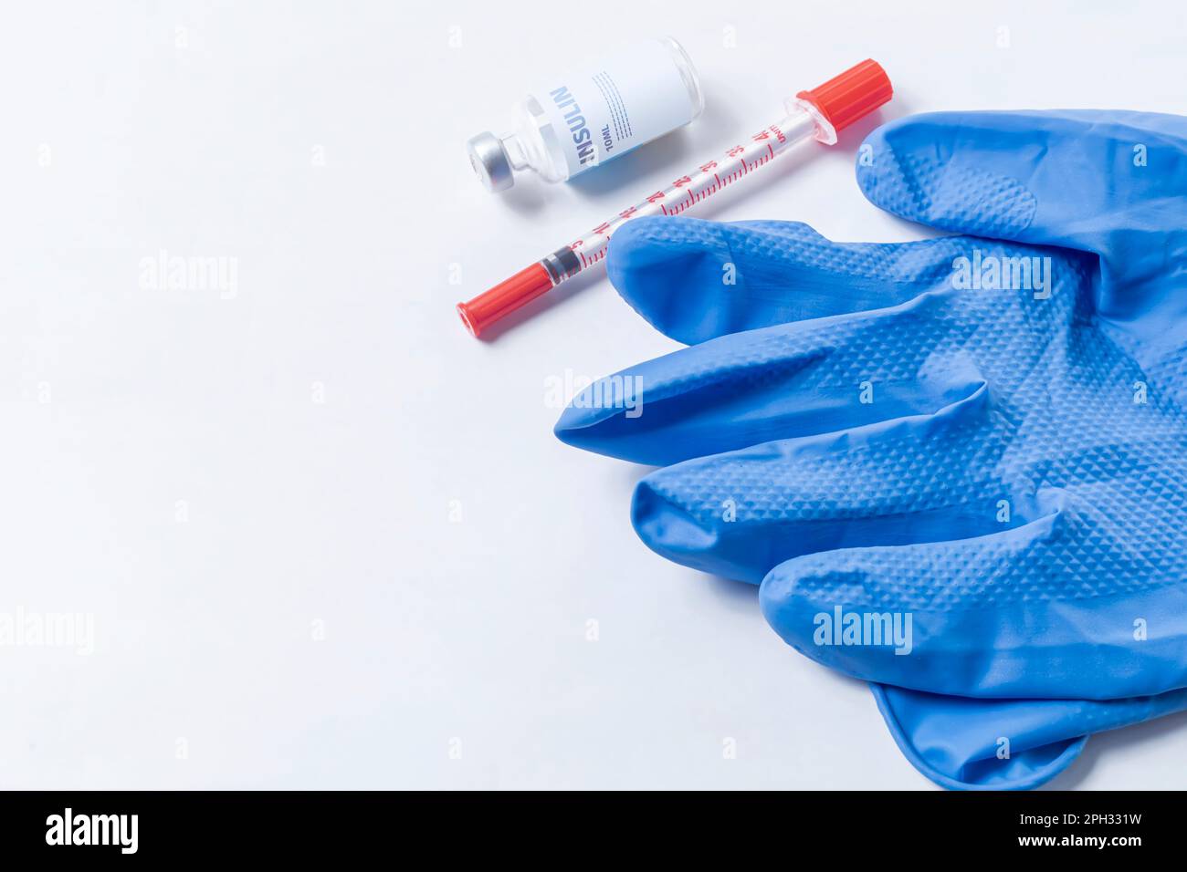 Medical gloves and a syringe with a glass vial on a white background ...