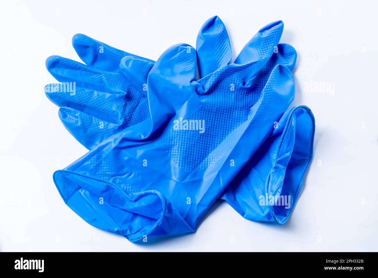 Two blue surgical gloves isolated on white background Stock Photo - Alamy