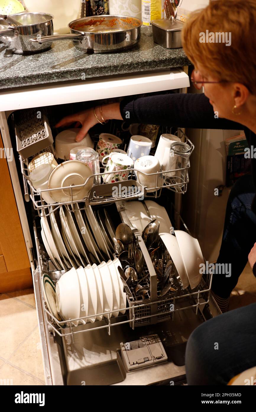 Woman stacking and loading the dishwasher the way she wants it! Stock ...