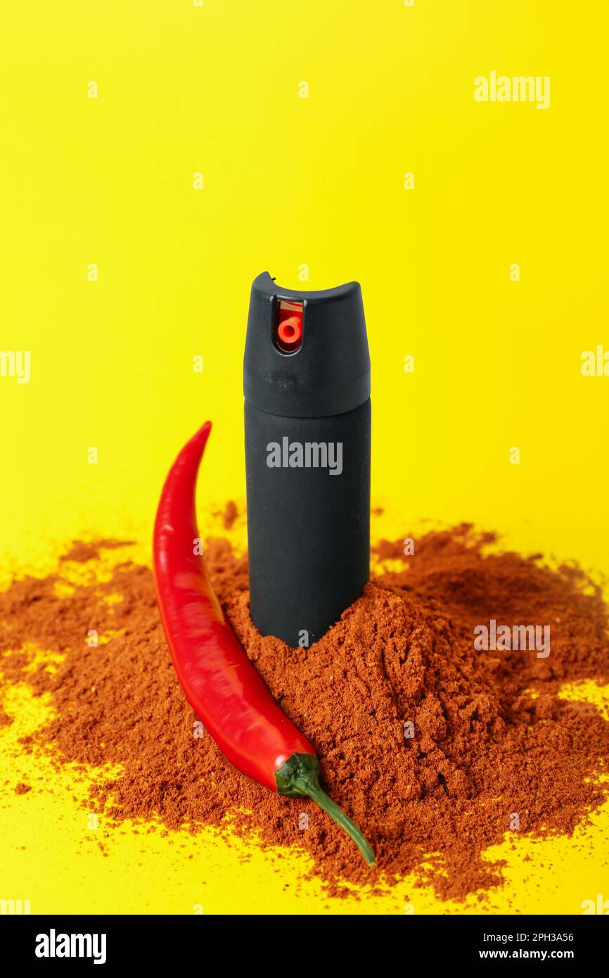 Spray with chili pepper and powder on yellow background Stock Photo - Alamy