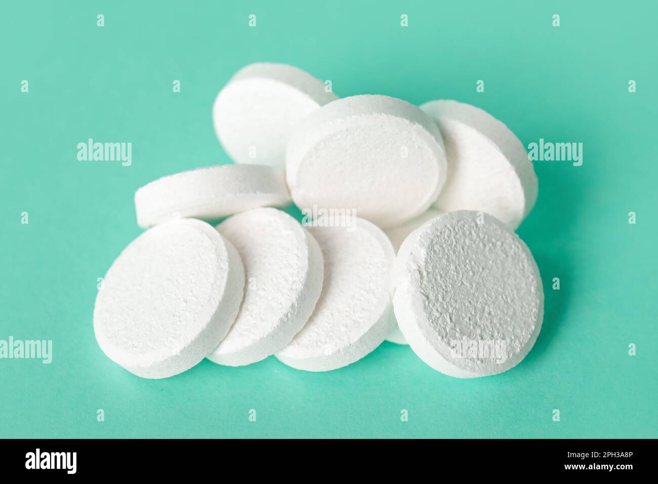 White soluble tablets on turquoise background Stock Photo - Alamy