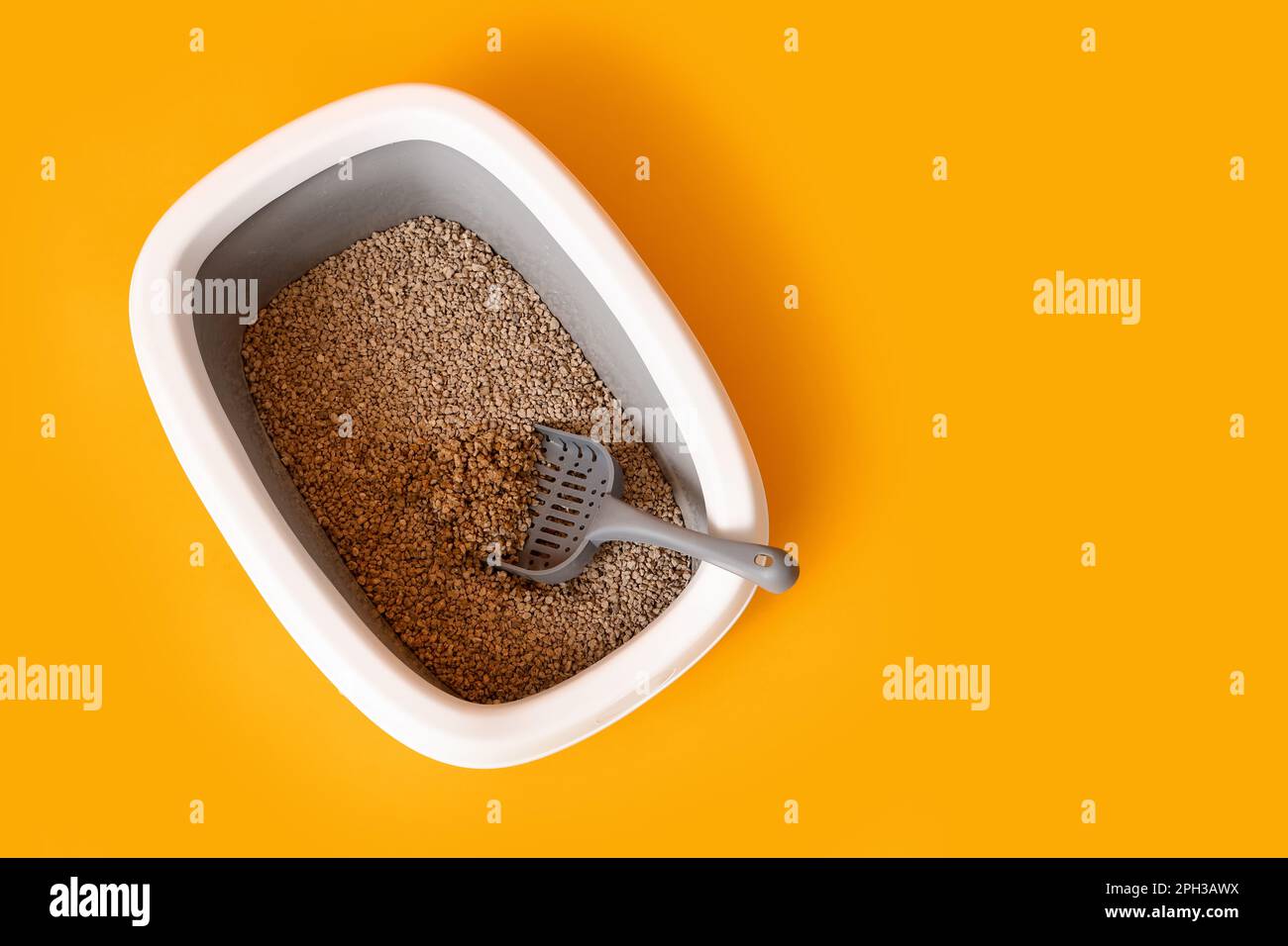 Litter box for cat on yellow background Stock Photo - Alamy