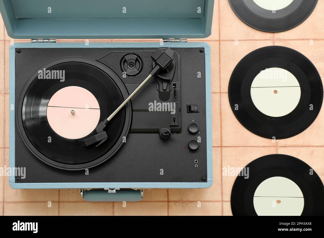 Record player with vinyl disks on beige tile background Stock Photo - Alamy