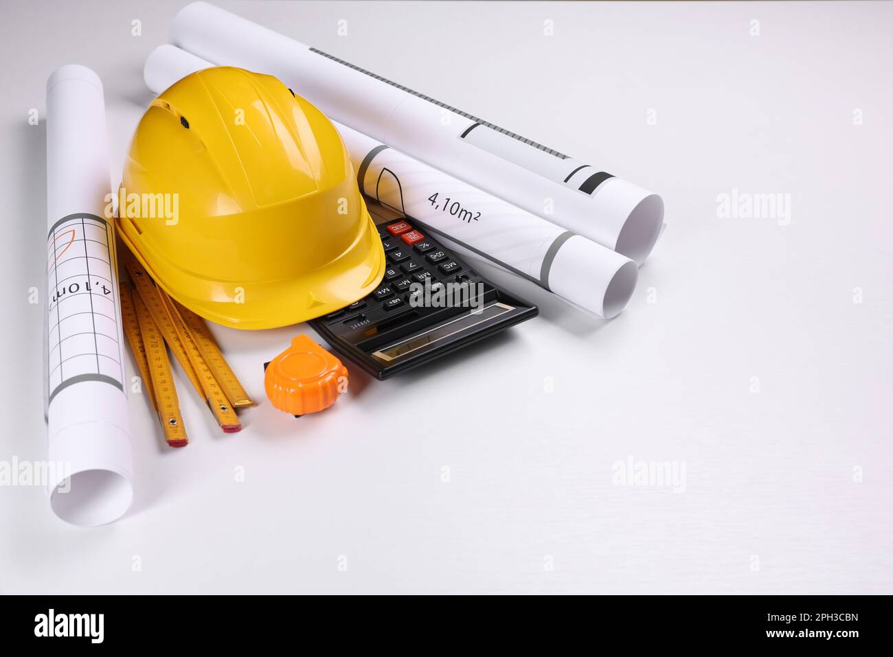 Construction drawings, safety hat, calculator, tape measure and folding ...