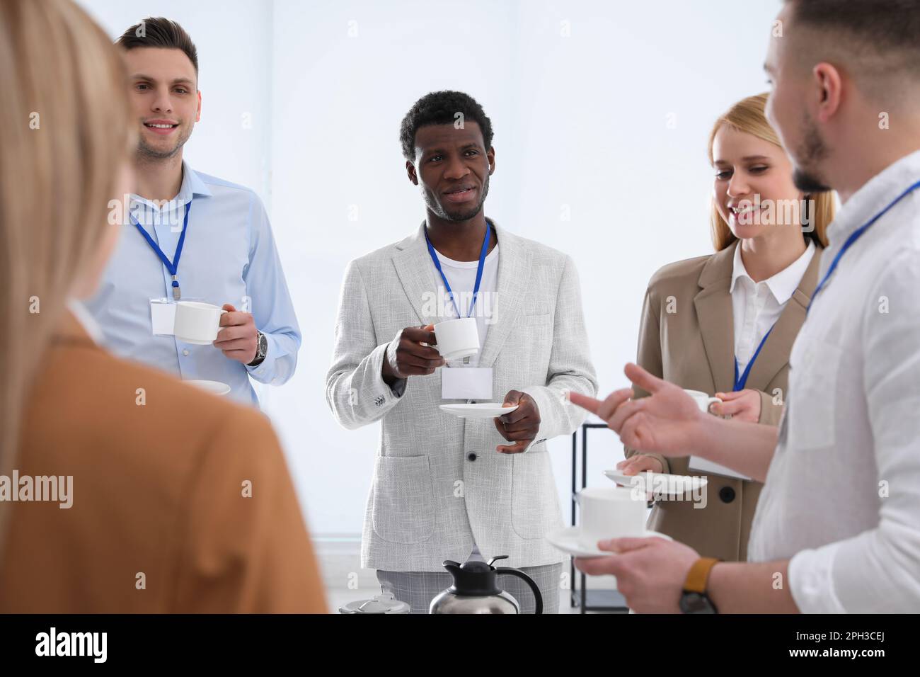 Group of people chatting during coffee break indoors Stock Photo - Alamy
