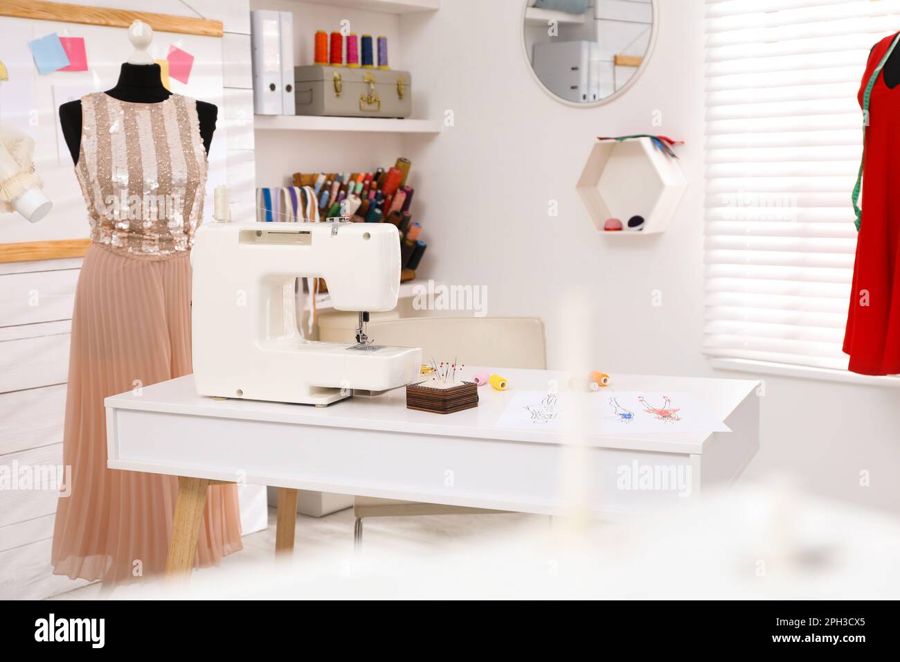 Dressmaking workshop interior with modern sewing machine, mannequin and ...