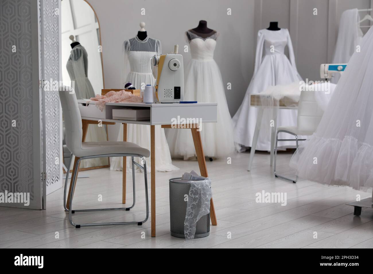 Dressmaking workshop interior with wedding dresses and equipment Stock ...