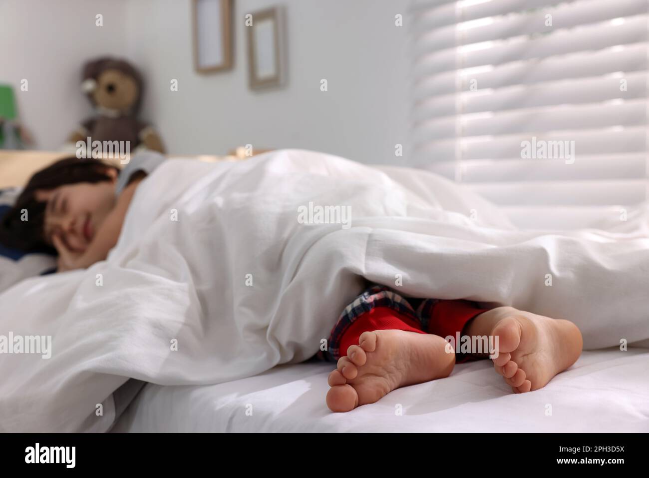 Little boy sleeping in bed at home, focus on feet Stock Photo - Alamy