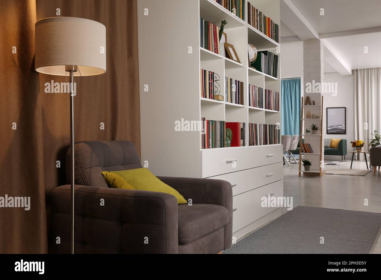 Cozy home library interior with comfortable armchair, floor lamp and ...