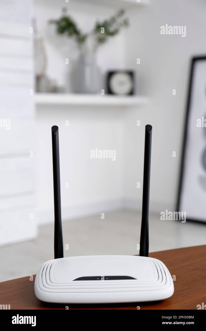Modern Wi-Fi router on wooden table indoors Stock Photo - Alamy