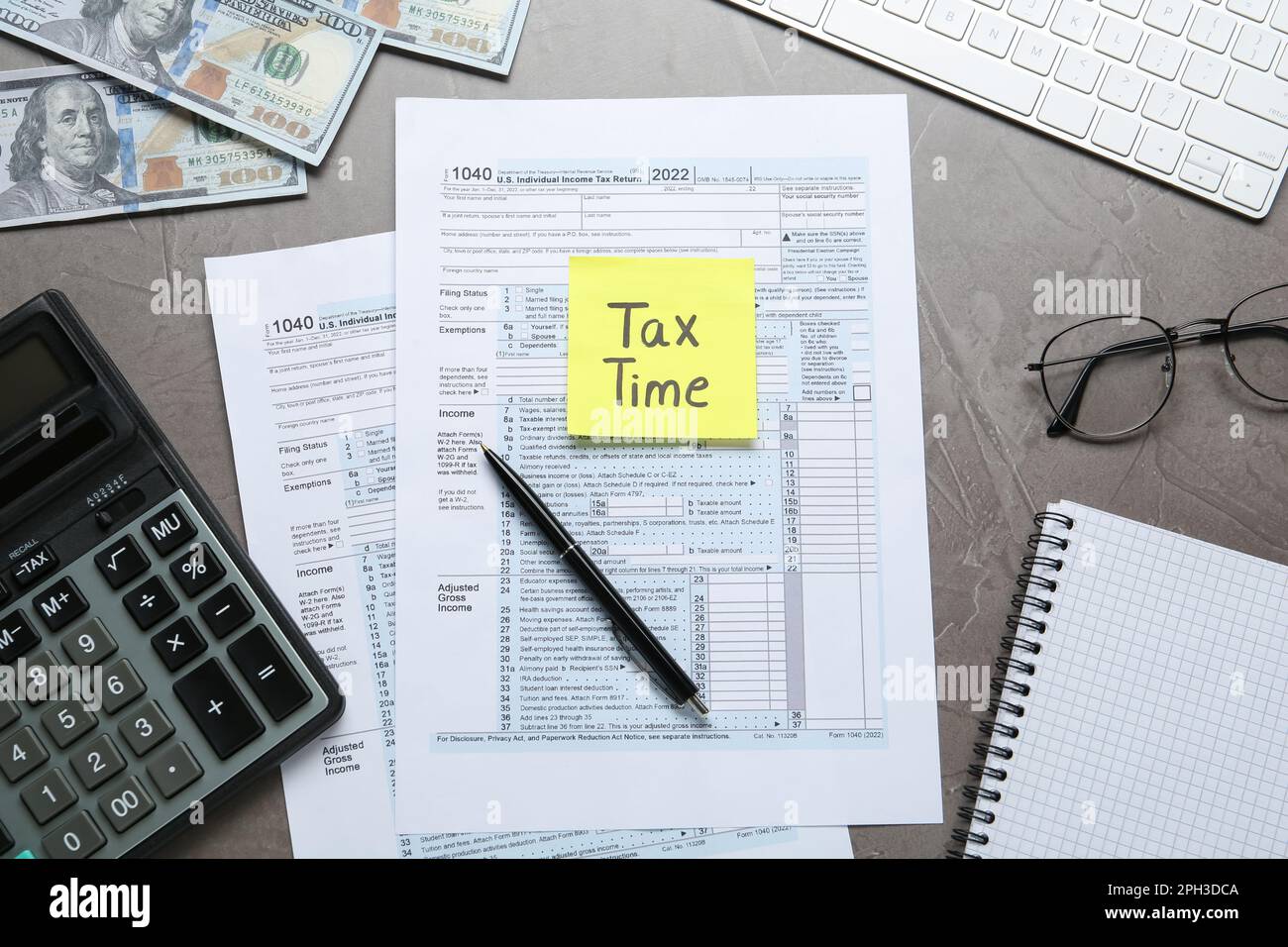 Reminder note with words TAX TIME, documents, keyboard, money and ...