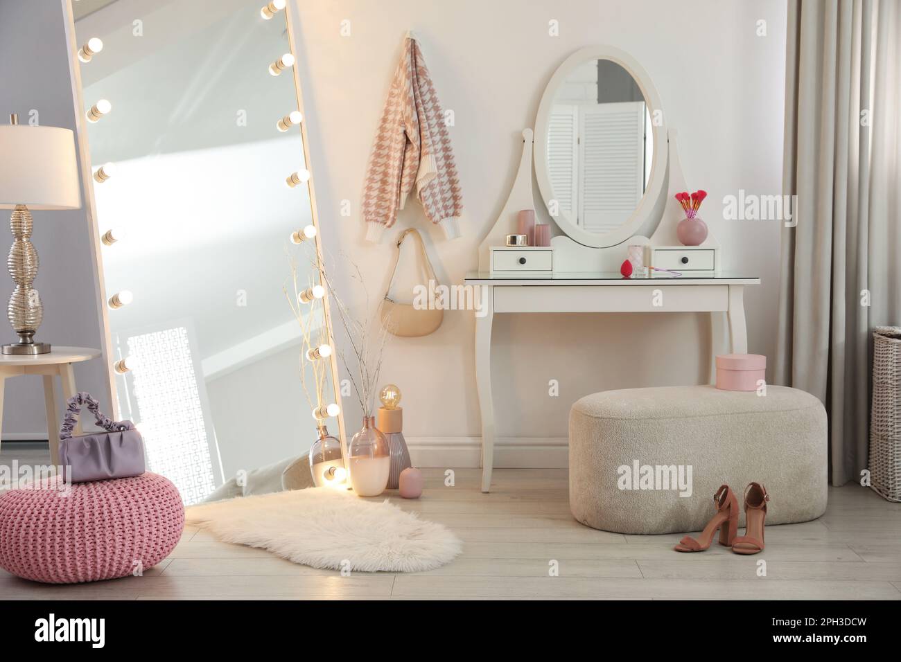 Large mirror with light bulbs and dressing table in stylish room ...