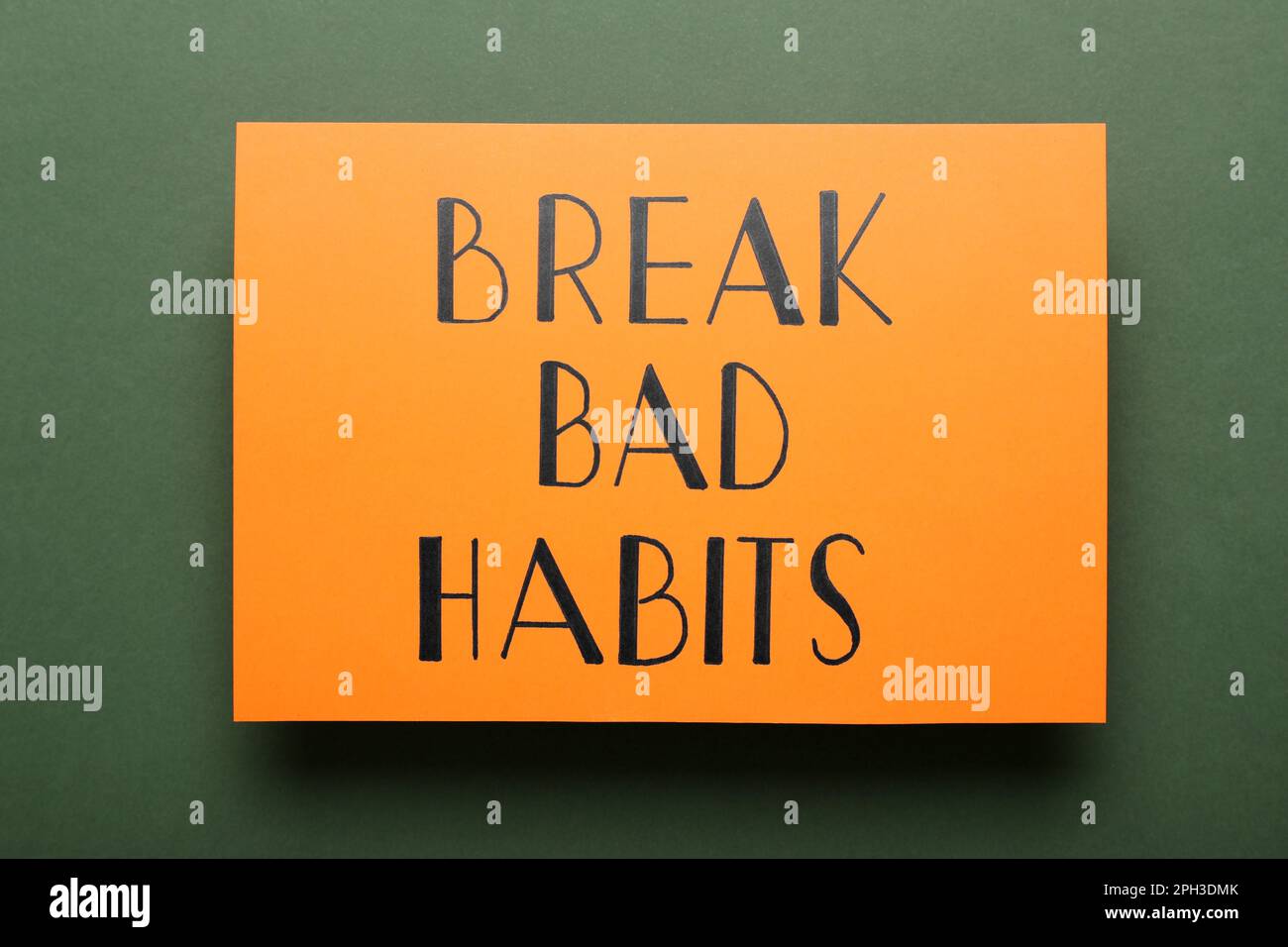 Orange sheet of paper with phrase Break Bad Habits on green background ...