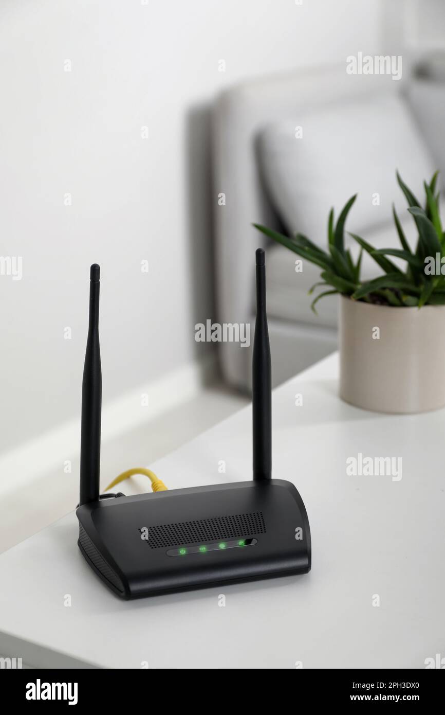 Modern Wi-Fi router on white table in room Stock Photo - Alamy