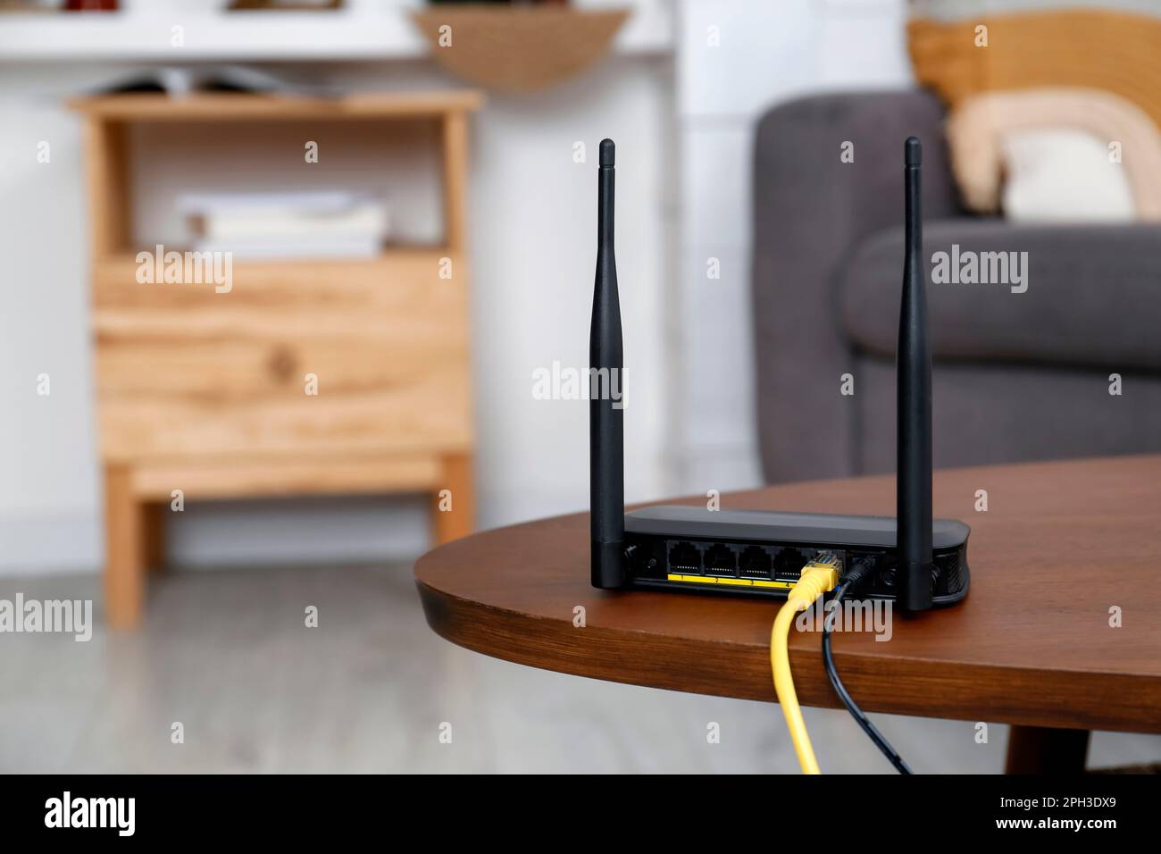Modern Wi-Fi router on wooden table indoors. Space for text Stock Photo - Alamy