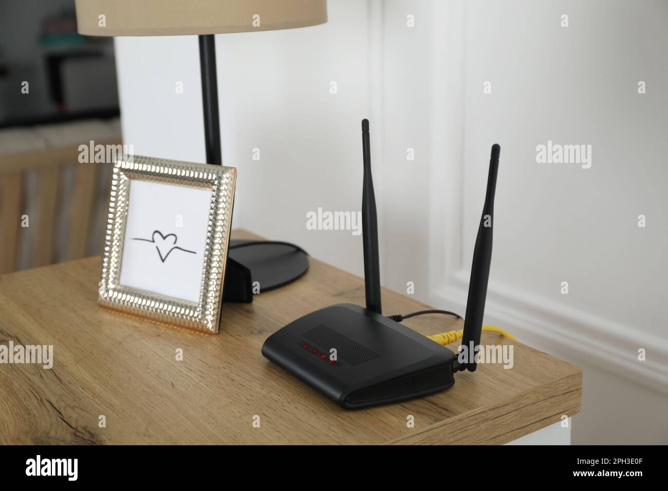 Modern Wi-Fi router on wooden table in room Stock Photo - Alamy