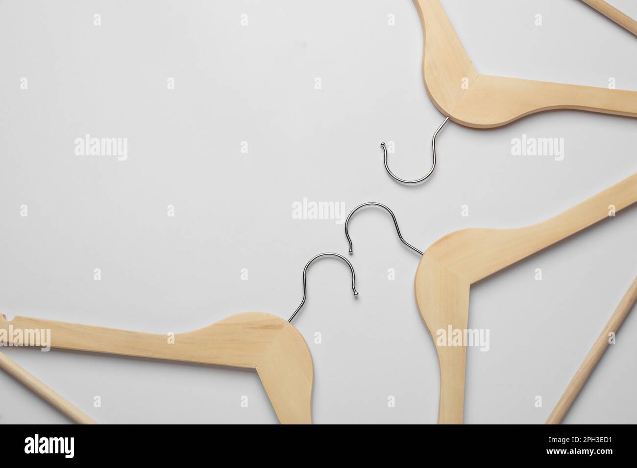 Empty wooden hangers on light grey background, flat lay. Space for text ...