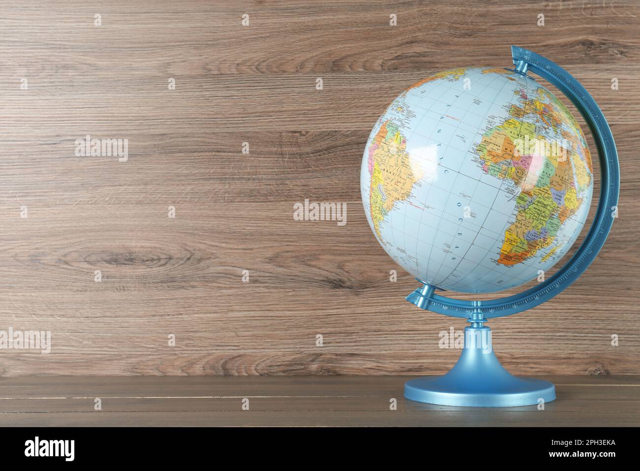 Plastic model globe of Earth on wooden table, space for text. Geography ...
