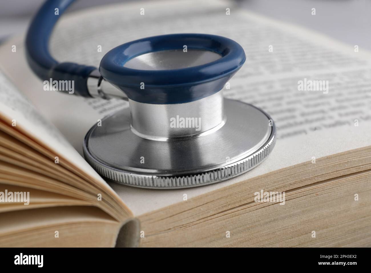 Open student textbook with and stethoscope, closeup. Medical education ...