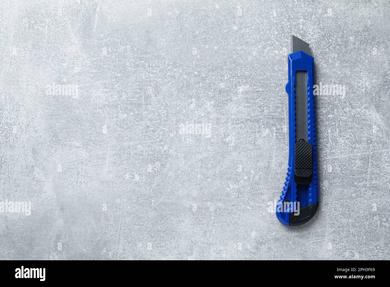 Blue utility knife on light grey table, top view. Space for text Stock ...