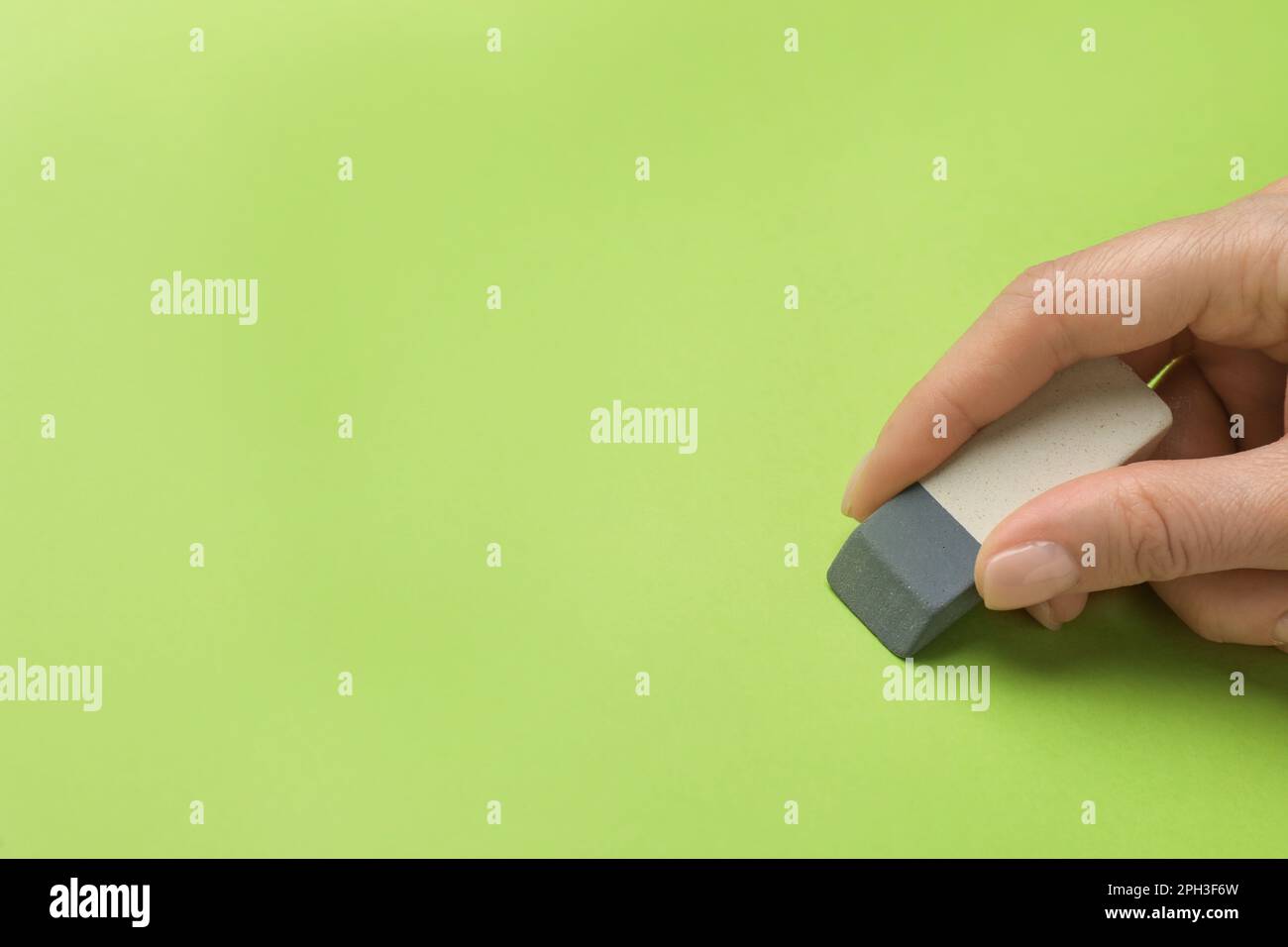 Woman erasing something on green background, closeup. Space for text ...