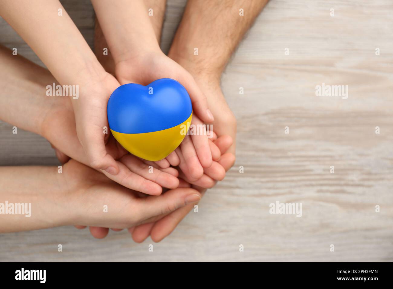 Stop war in Ukraine. Family holding heart shaped toy with colors of ...