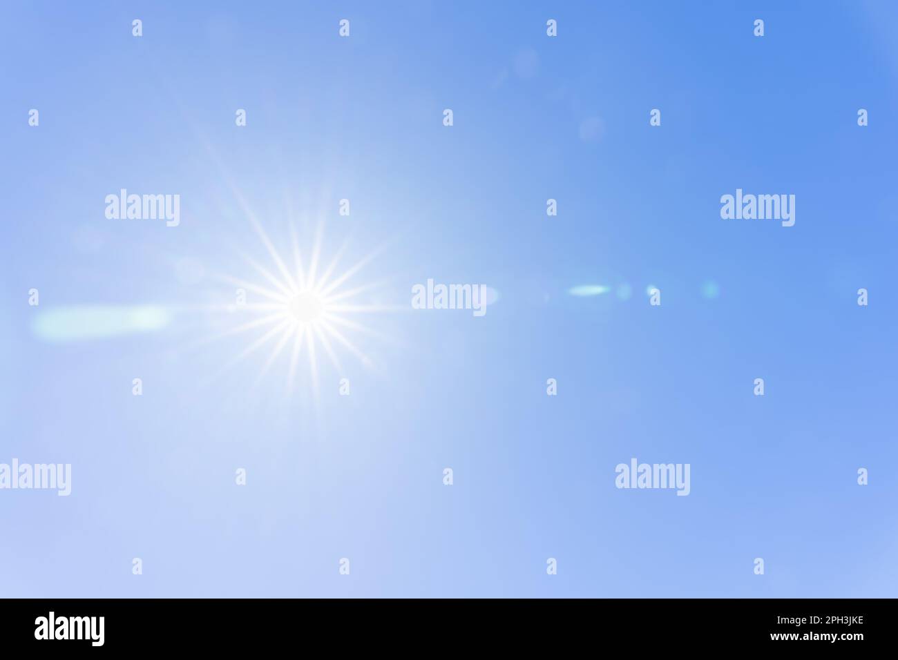 Sun flare in blue sky with lens flare effect background Stock Photo - Alamy