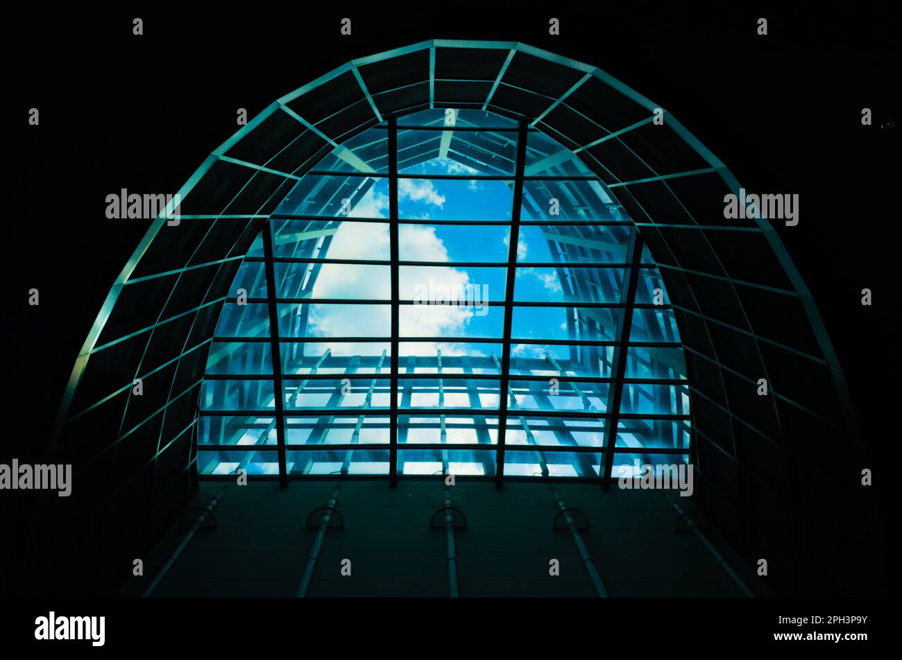 A piece of bright blue sky and fluffy clouds appear to be caged by the ...