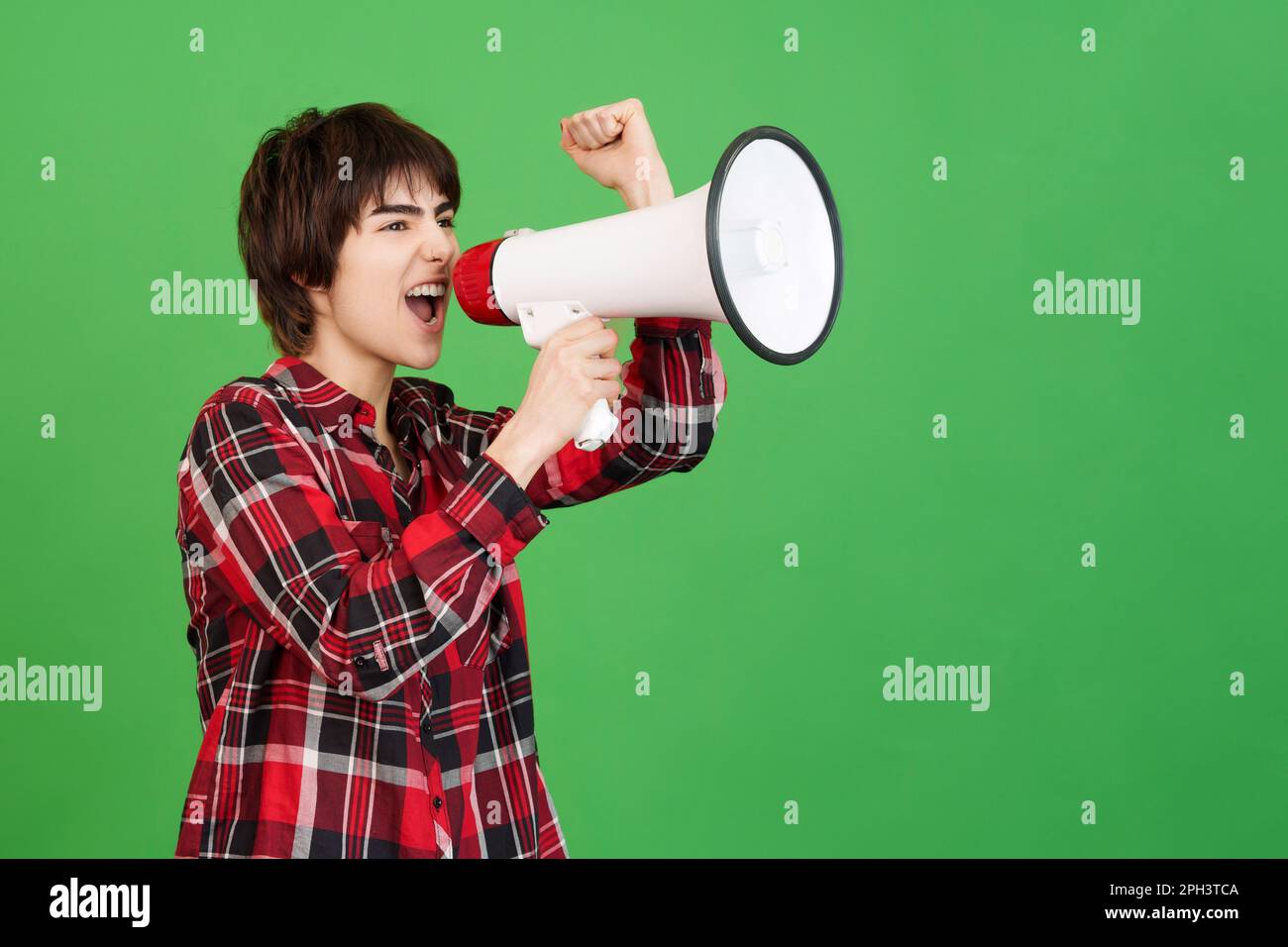 Androgynous person yelling while using a megaphone Stock Photo - Alamy