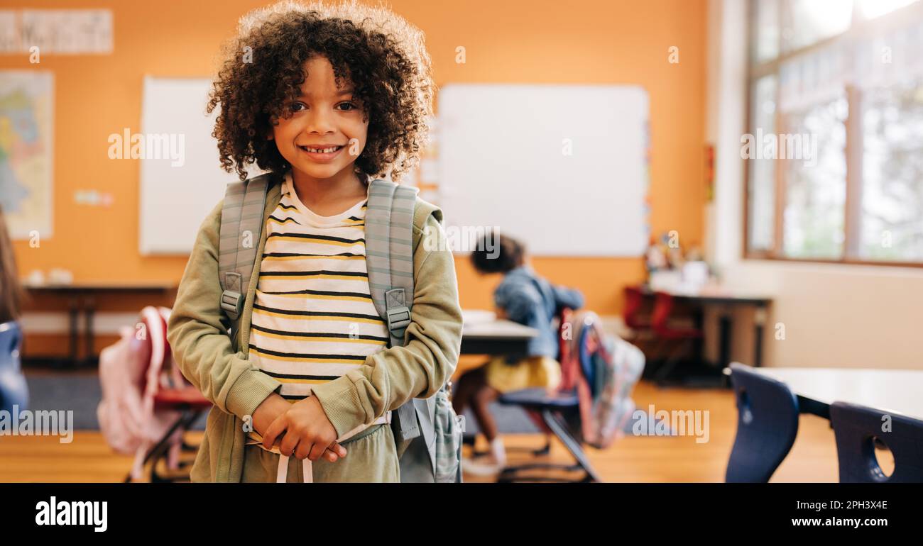 Young male student smiling and looking at camera on first day of co-ed ...