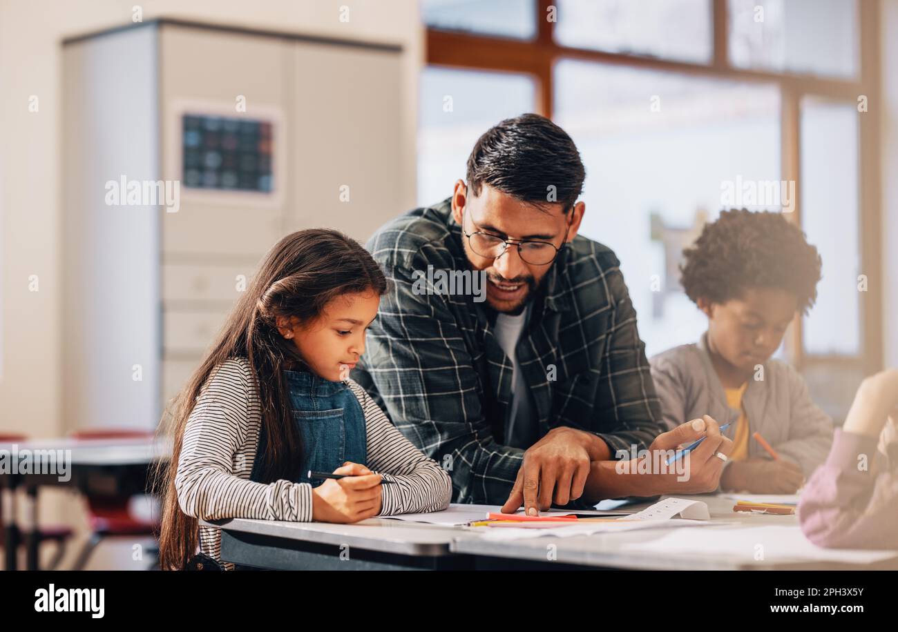 Man mentoring elementary school children. Teacher showing kids how to ...