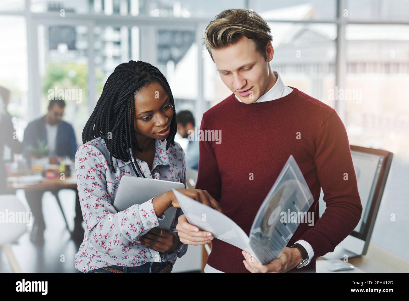 The report looks ready for submission. two young colleagues discussing ...