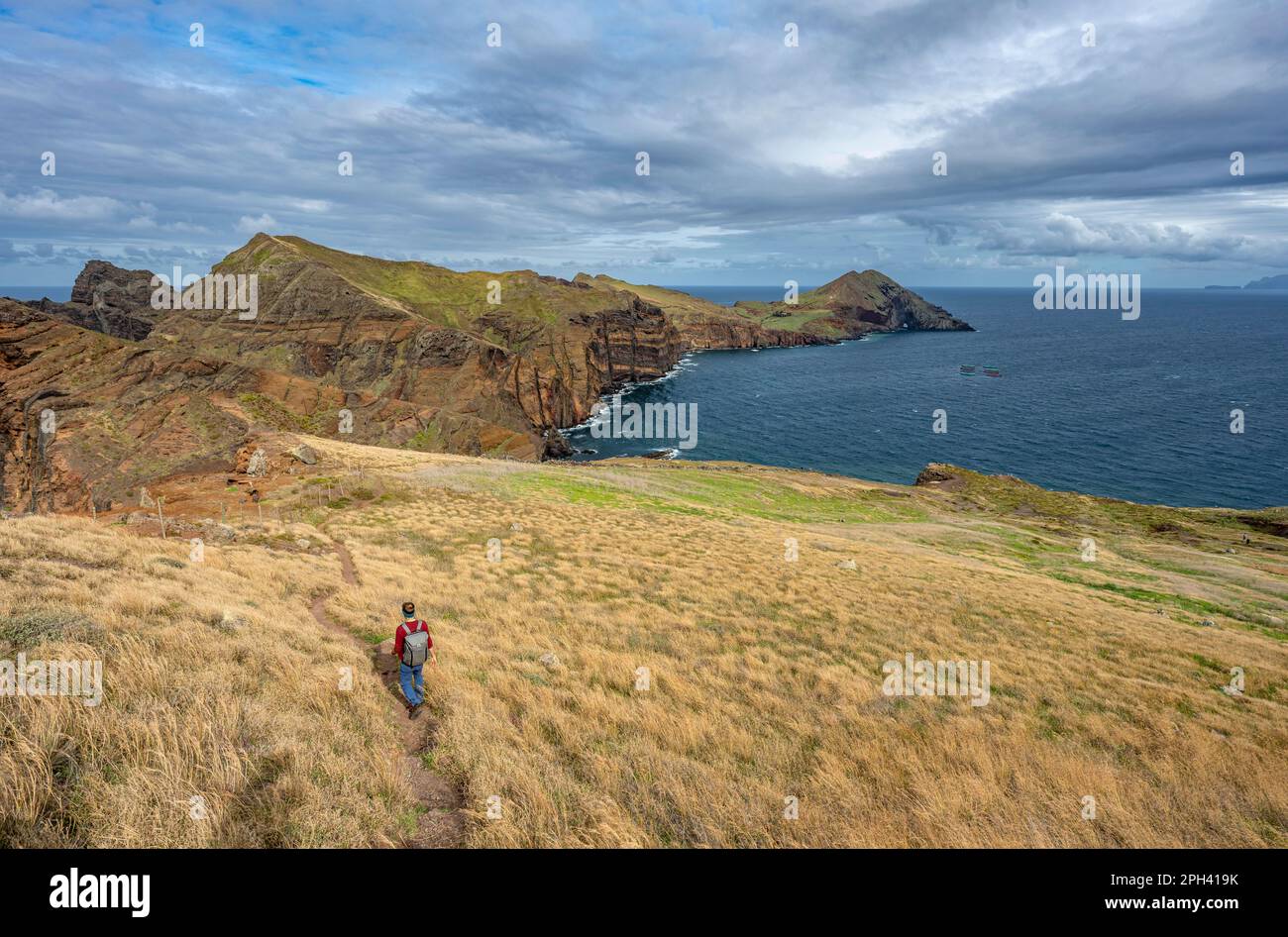 Hikers on the rocky promontory, coastal landscape, cliffs and sea, rugged coast with rock ...