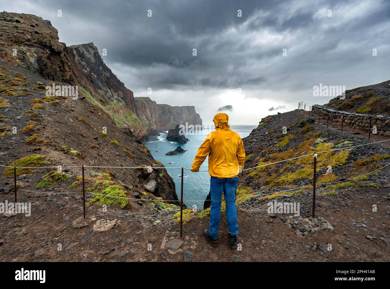 Hikers at the viewpoint, coastal landscape with red cliffs and sea ...