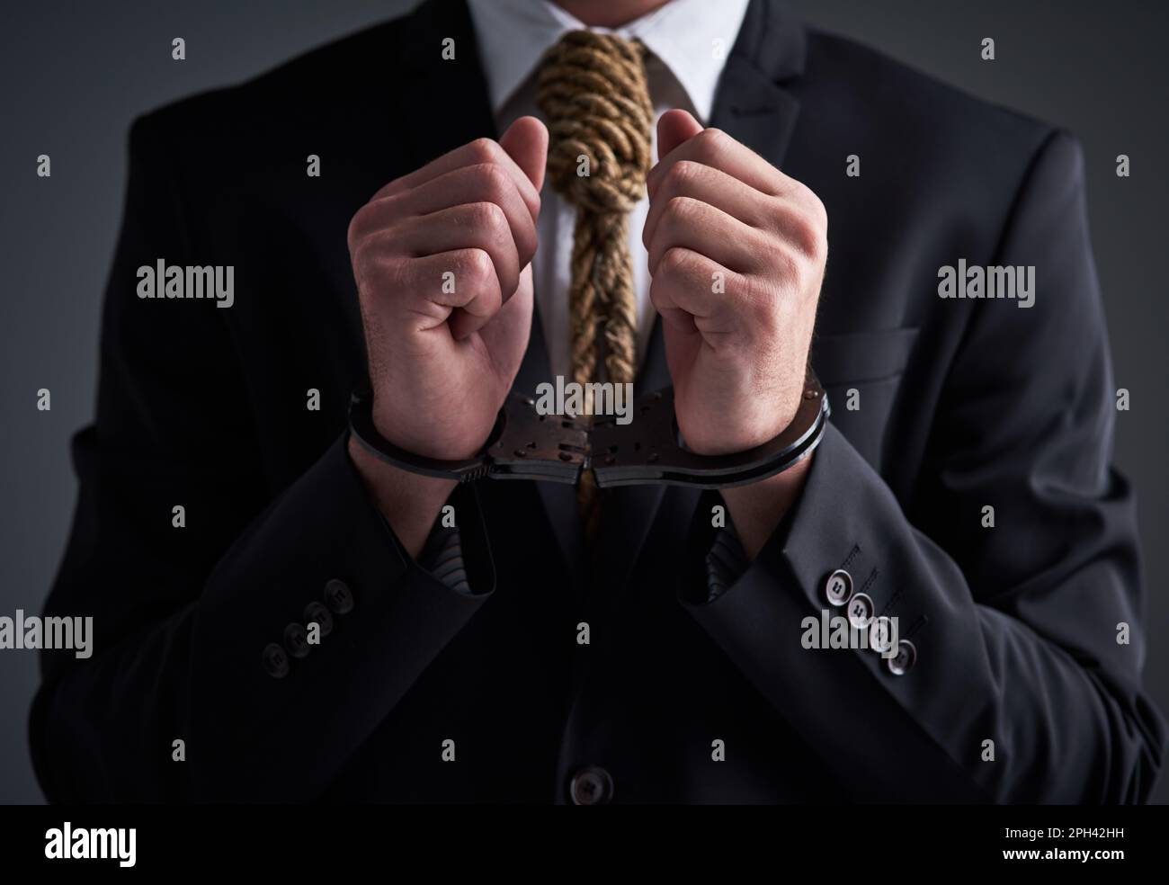 Crime doesnt pay. Studio shot of a handcuffed businessman with a noose ...