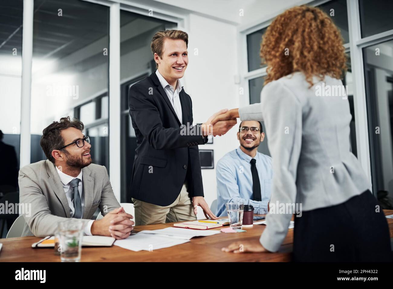 Youre hired. two businesspeople shaking hands during a job interview in ...