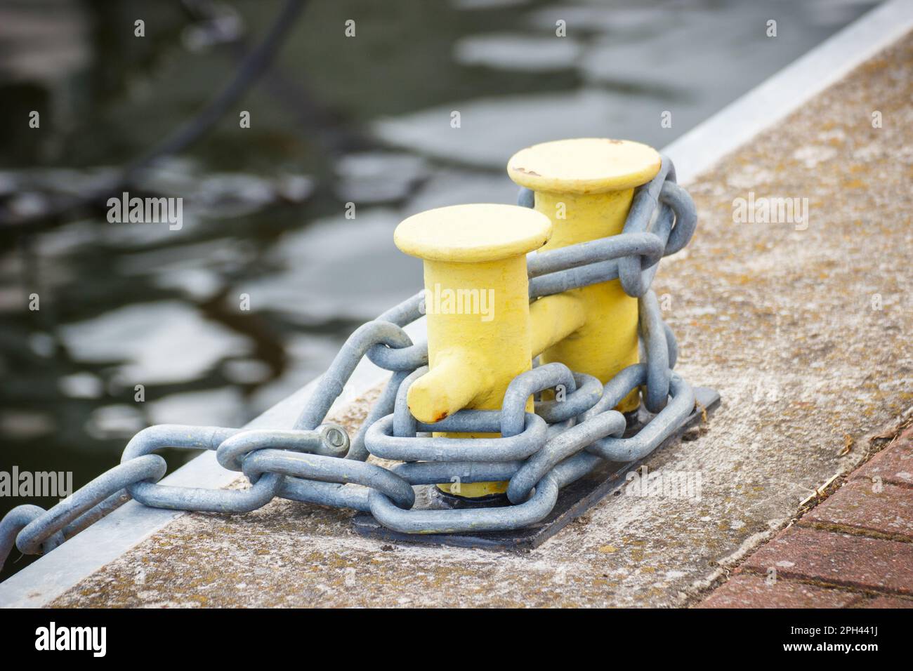Metal chains with yellow bollards on bridge. Part of yacht anchor ...