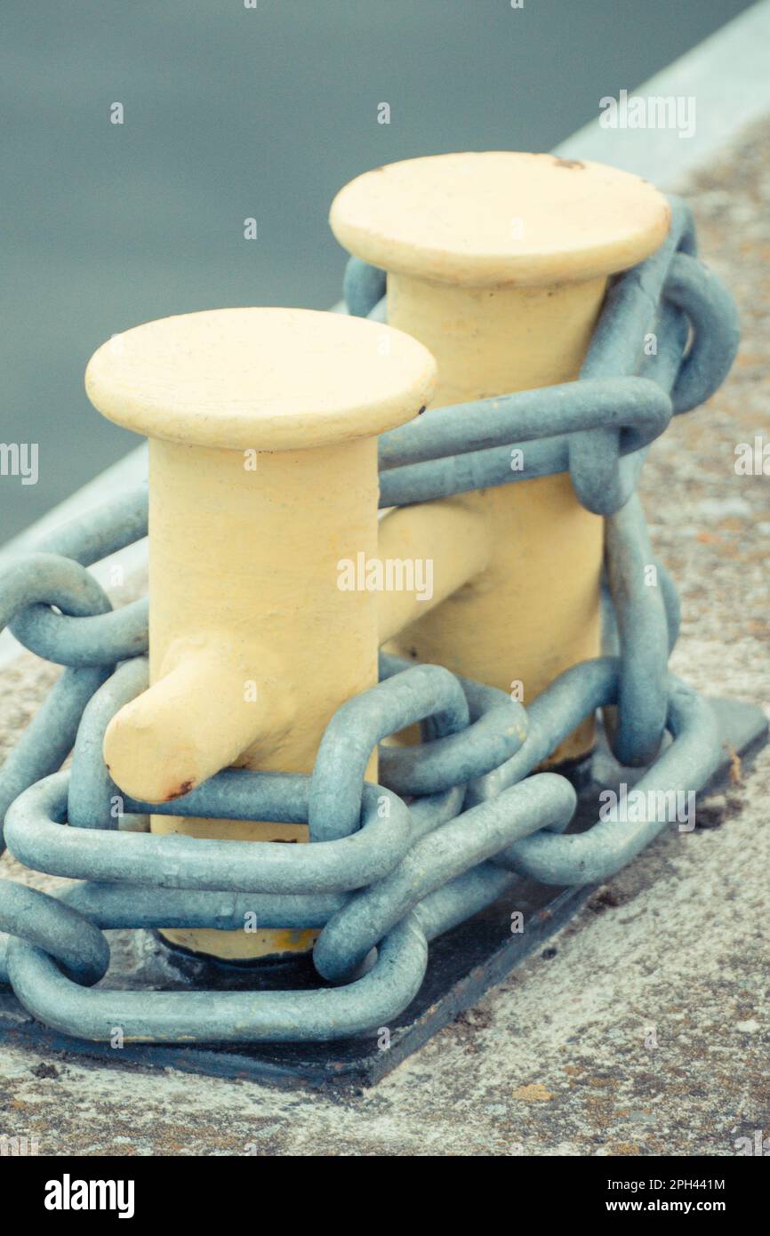 Metal chains with yellow bollards on bridge. Part of yacht anchor ...