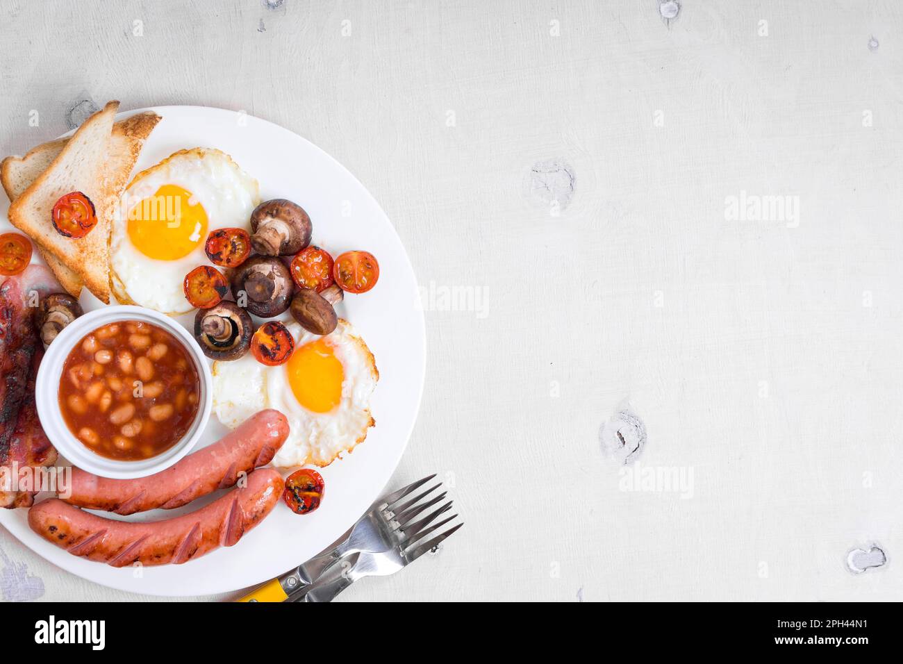 Full english breakfast with fried eggs, tomatoes, sausages, bacon ...