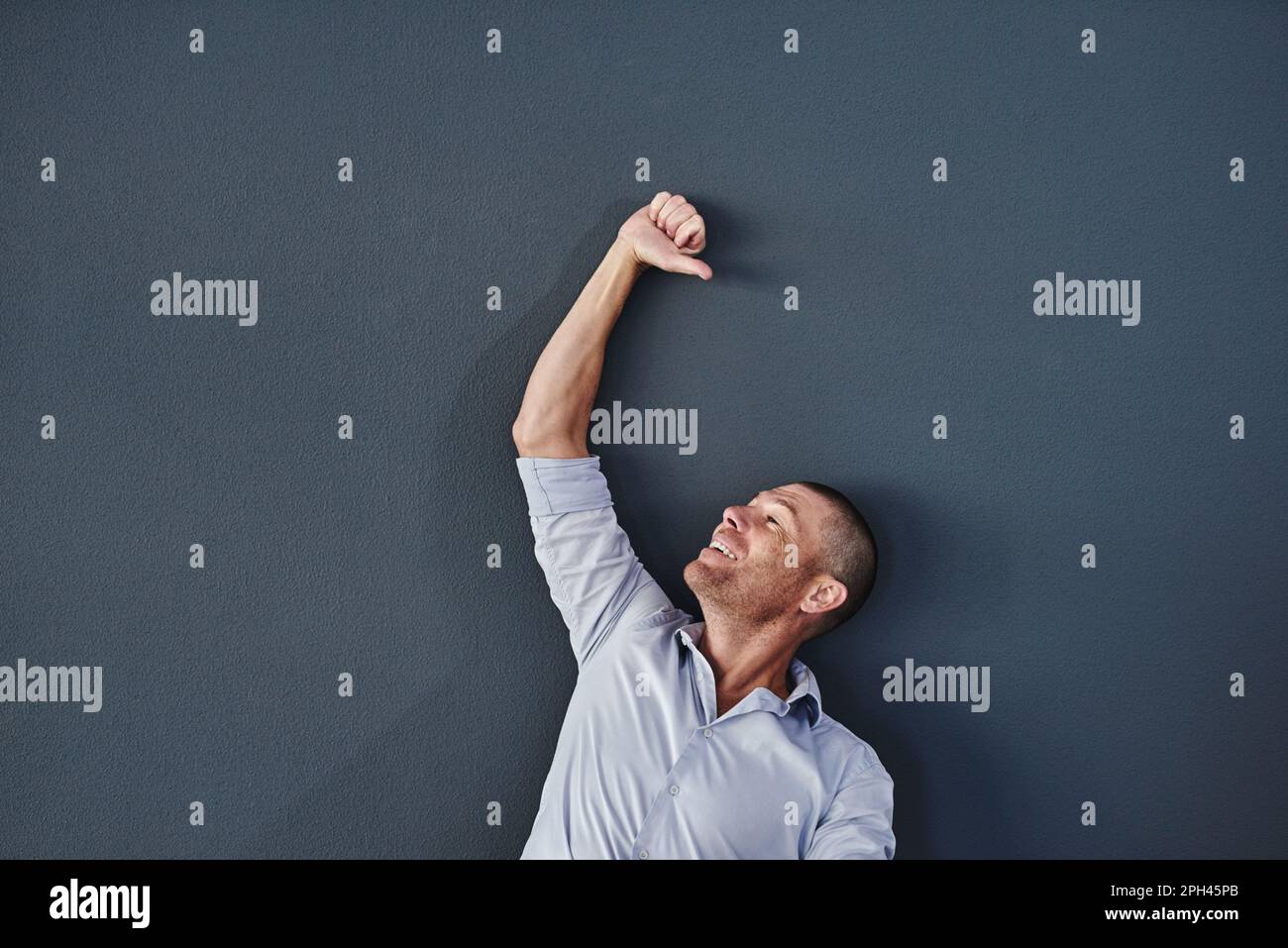 Expressing himself. Studio shot of a mature man raising his hand ...