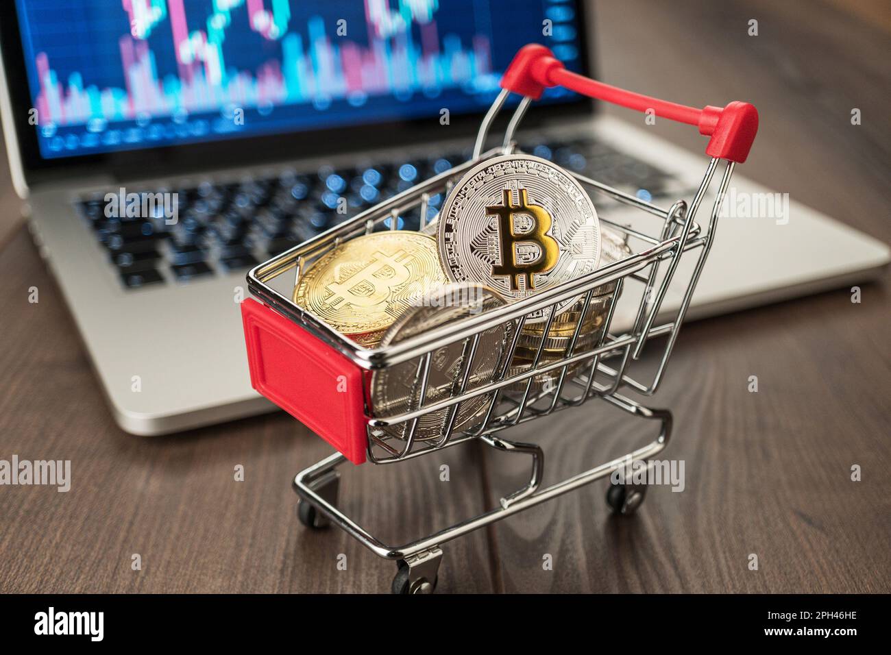shopping trolley full of bitcoin currency with laptop showing stock ...