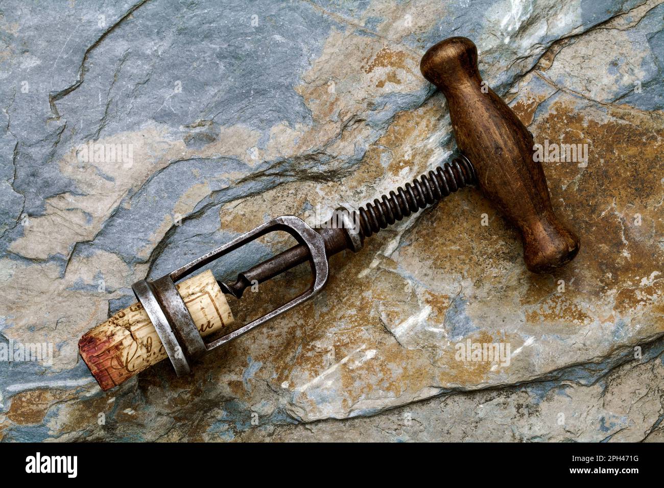 old corkscrew with a cork on a stone background Stock Photo - Alamy