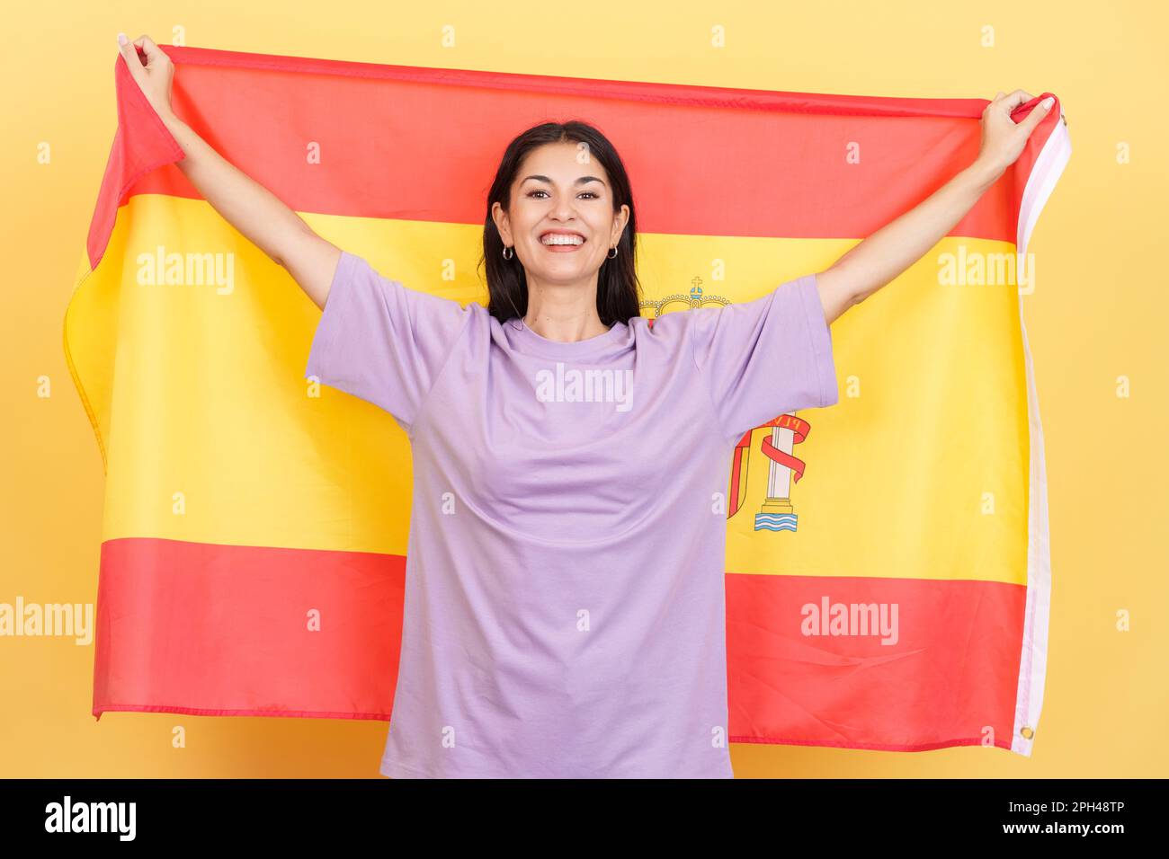 Happy caucasian woman smiling and raising a spanish national flag Stock ...