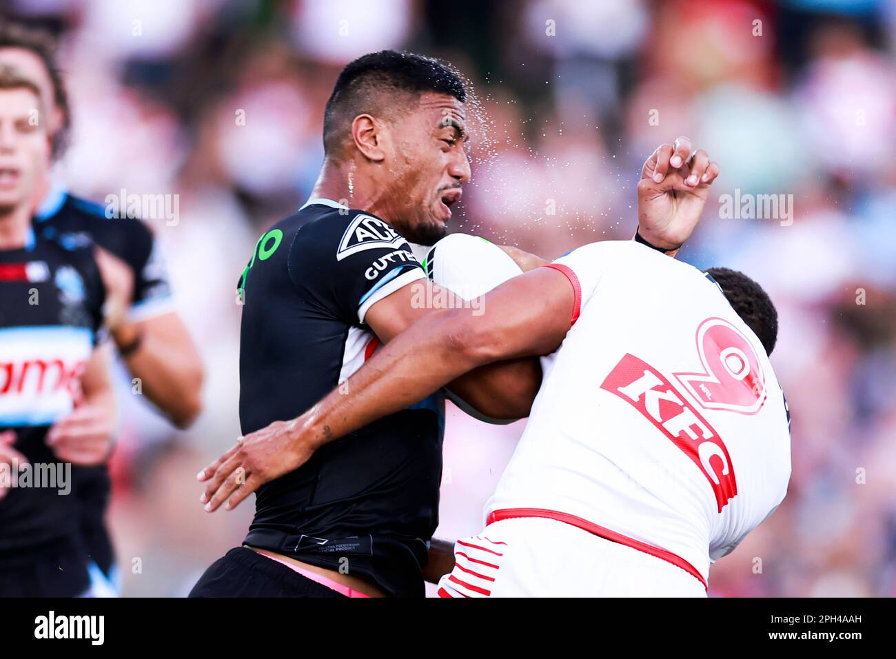 Toby Rudolf of the Sharks is tackled by Moses Mbye of the Dragons ...