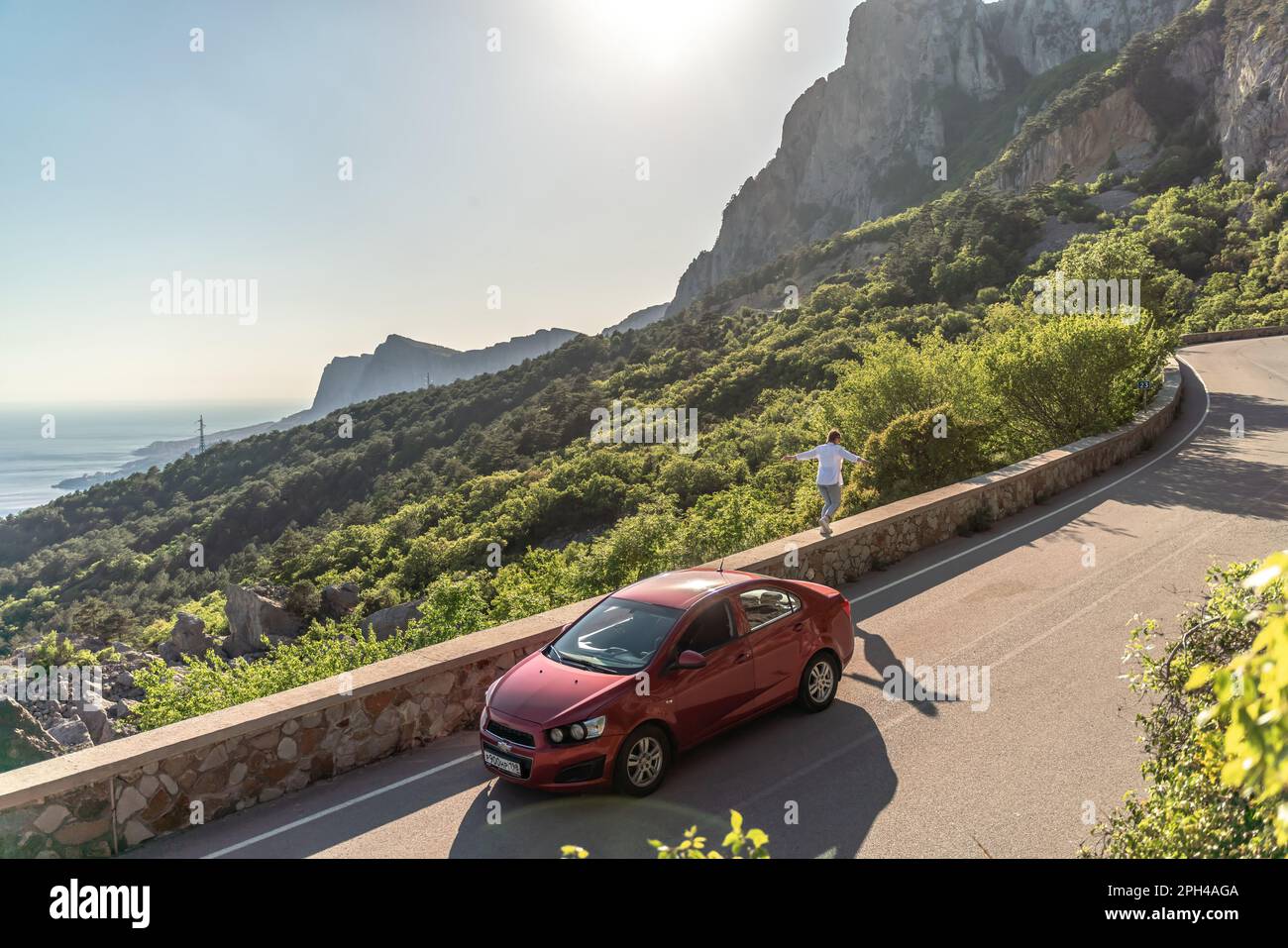 Mountain road woman. She walks along a parapet road in the middl Stock ...