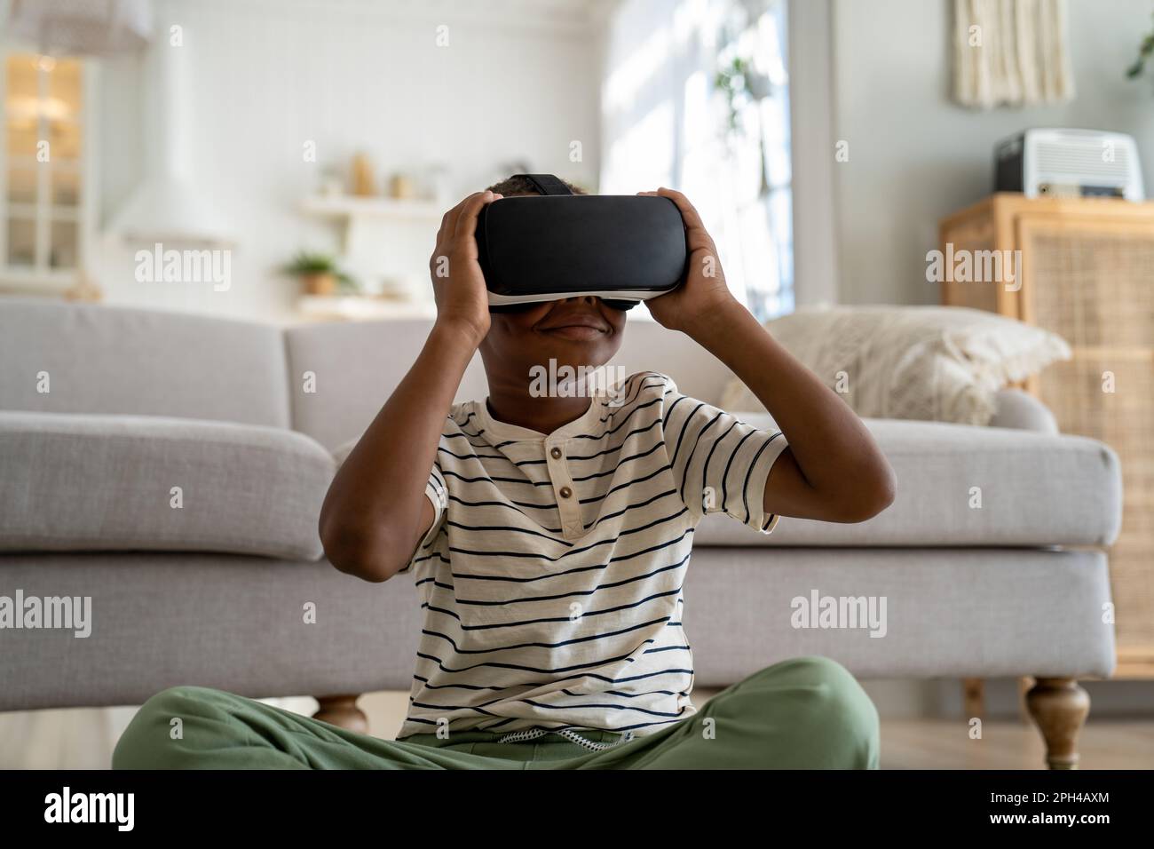 Obsessed child black boy experiencing 3D virtual reality in VR goggles ...