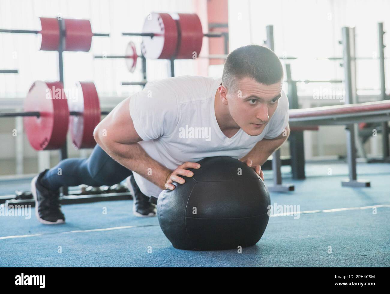 athlete push ups on a black ball in the gym Stock Photo - Alamy