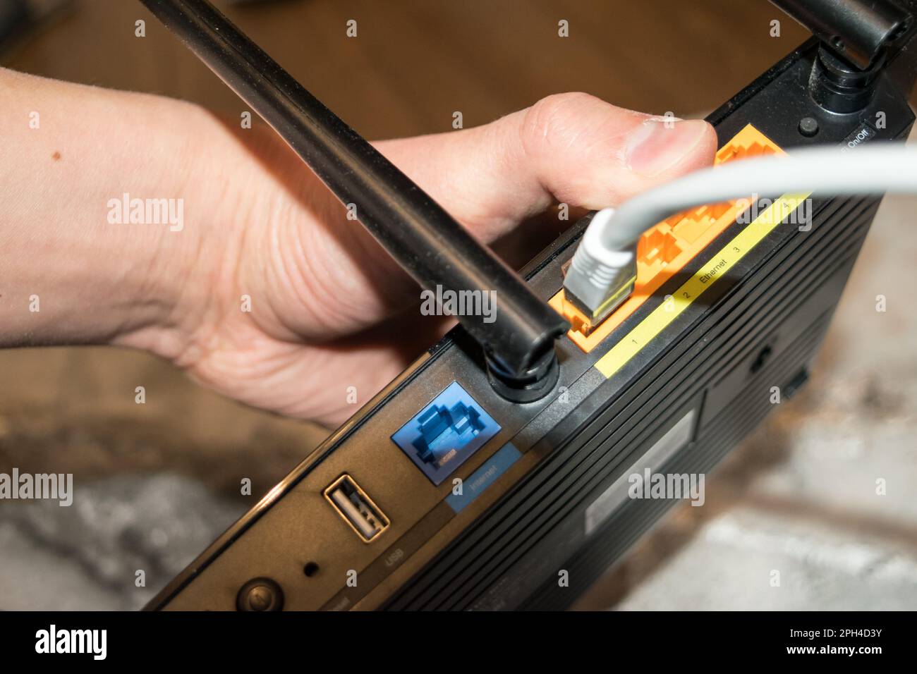 WiFi router, back of the router, hand holding the router with wires ...