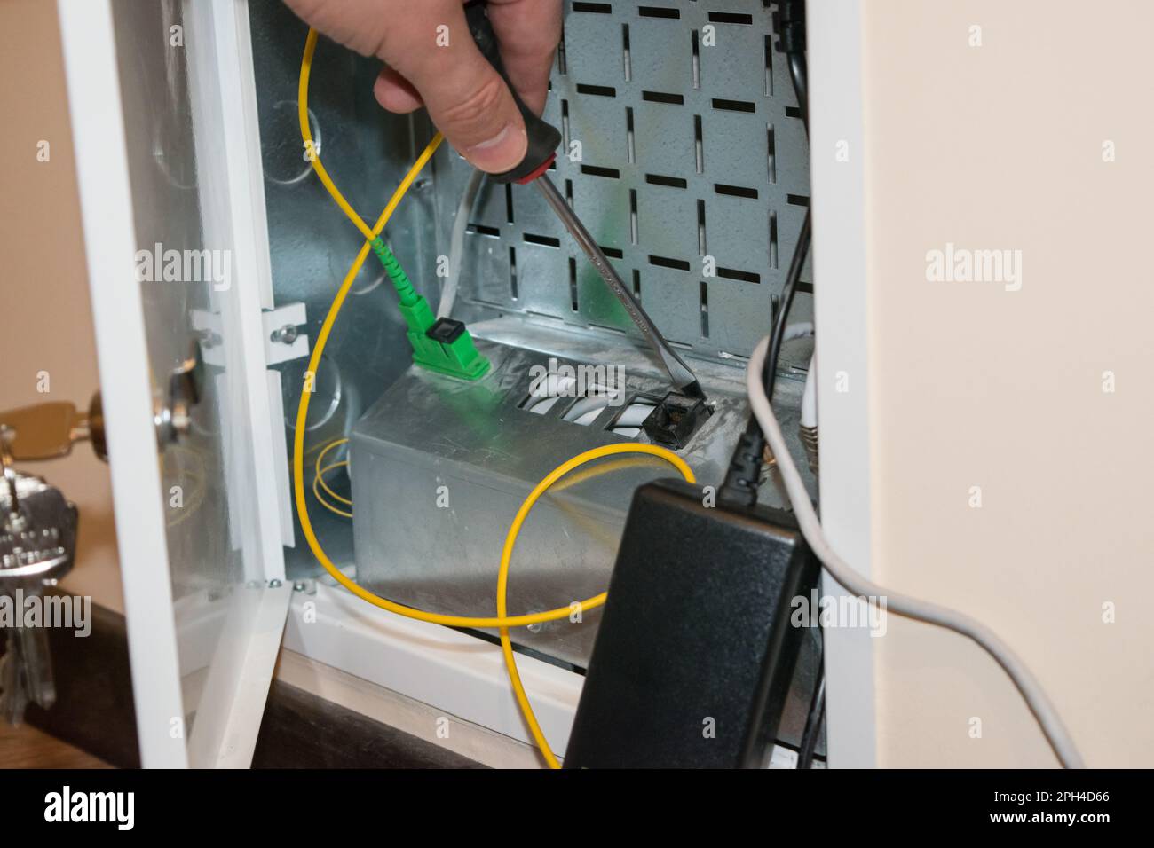 The router box is open, the human hand holds a screwdriver, there is a ...