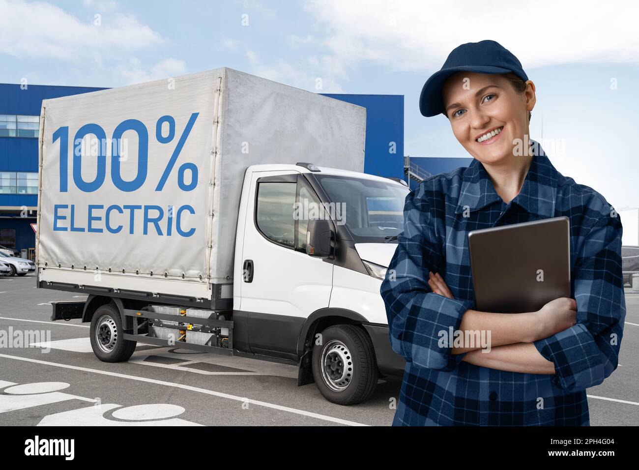 Fleet manager with a digital tablet stands next to electric truck. High ...